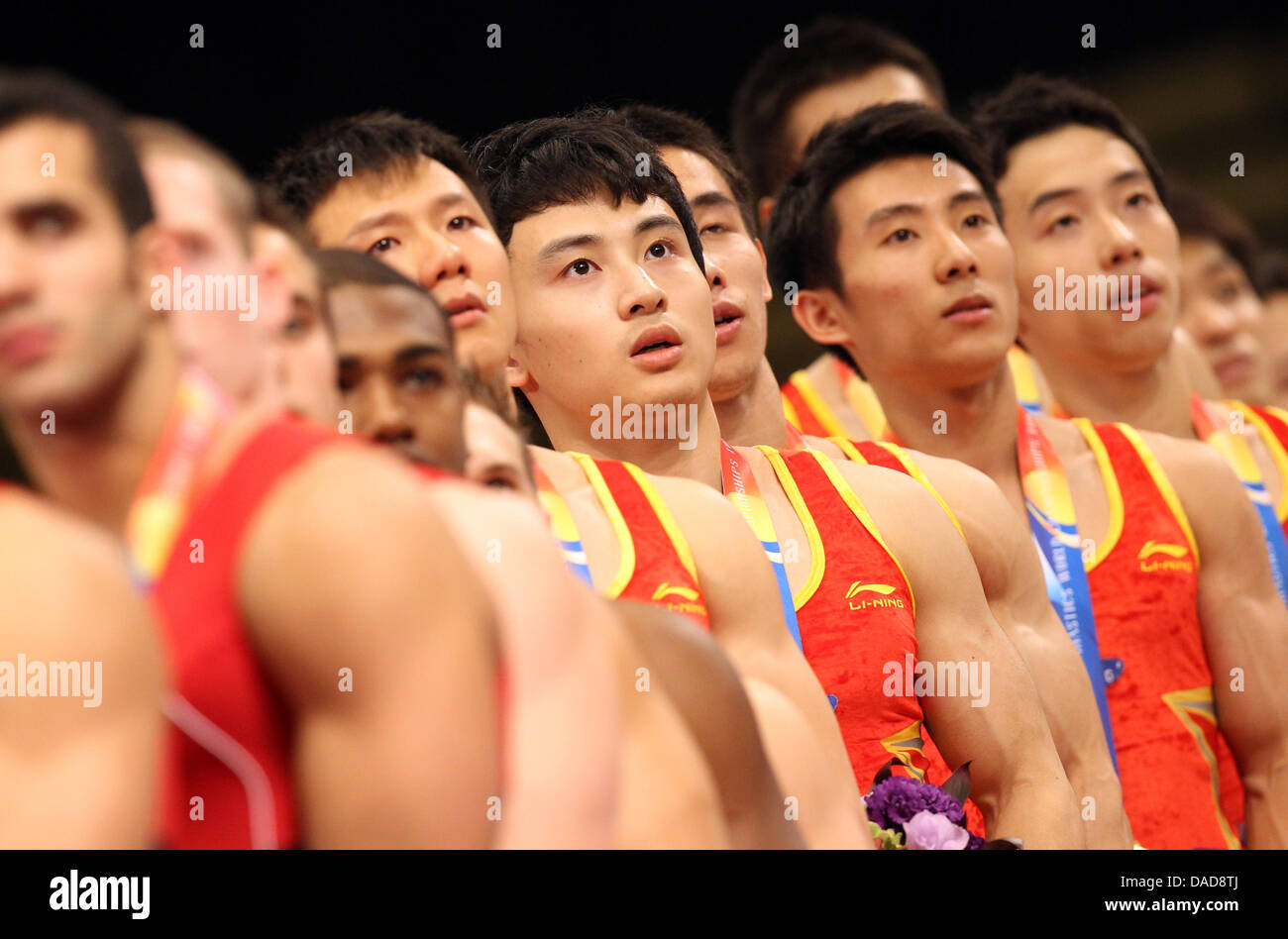 Chinese gymnasts pose with their gold medals on the podium after ...