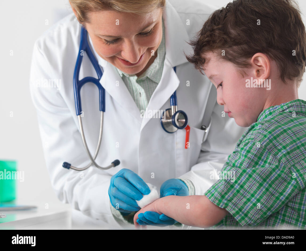 Doctor caring for small boy with injury Stock Photo - Alamy