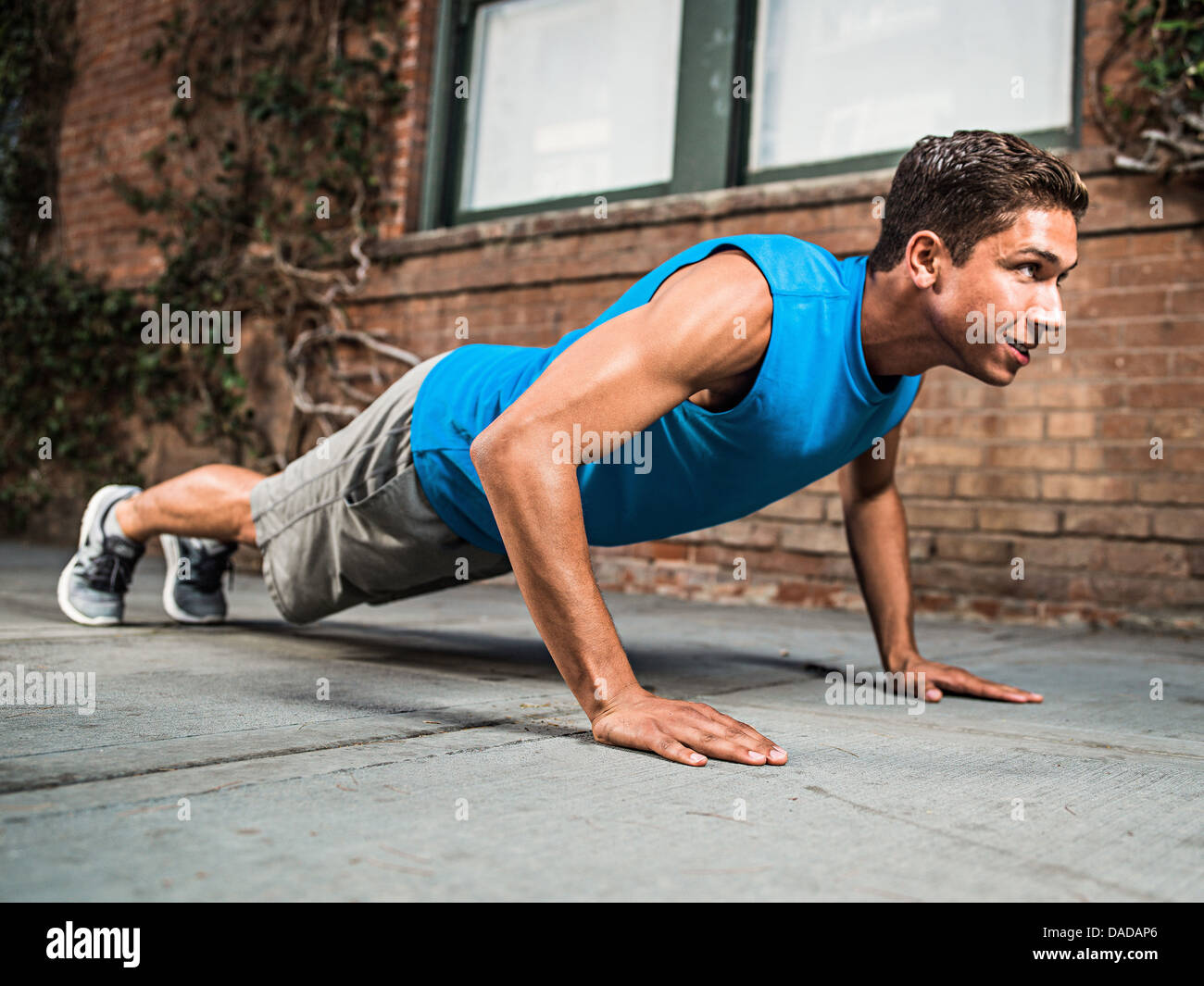 Young man doing push-up on city street Stock Photo - Alamy