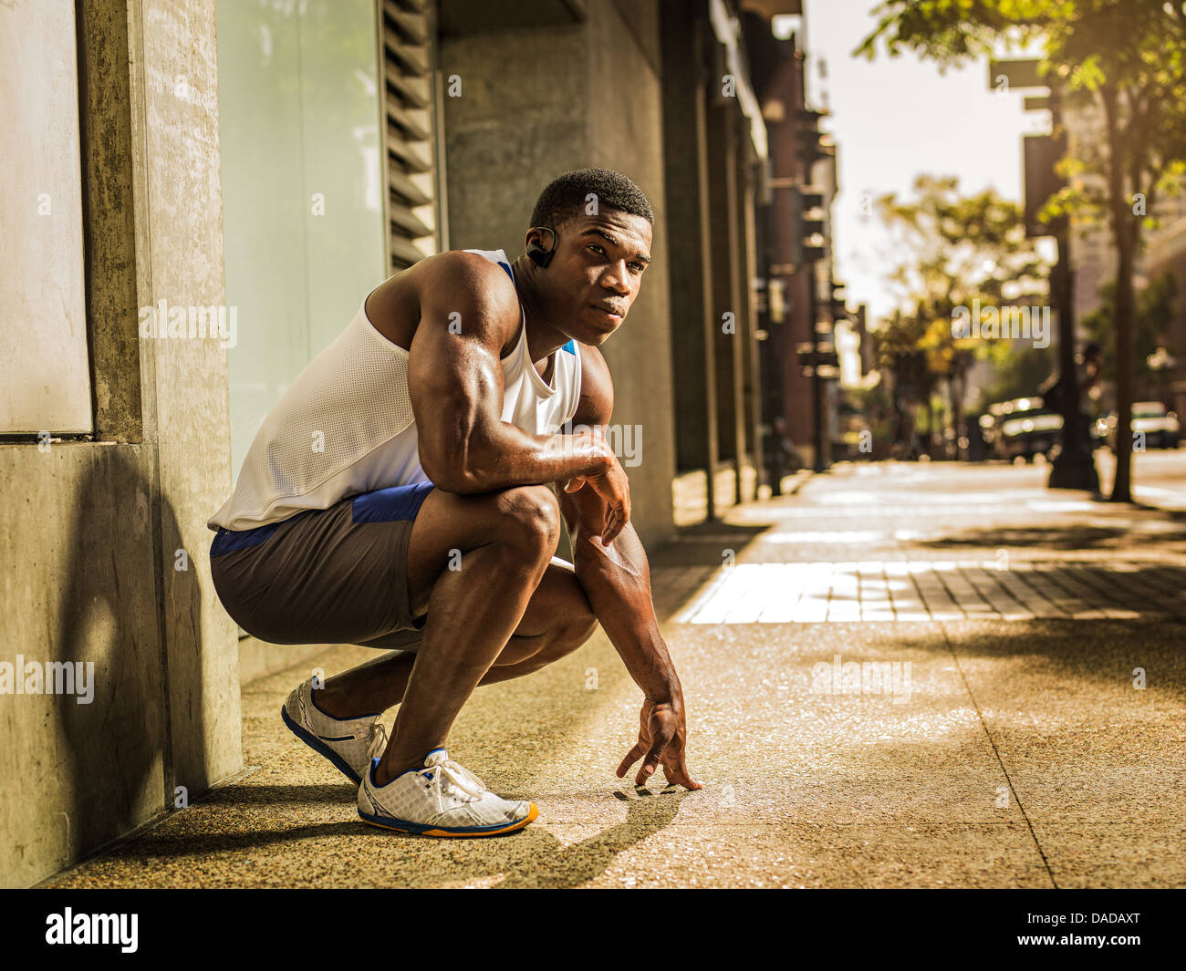 Runner crouching on street Stock Photo - Alamy