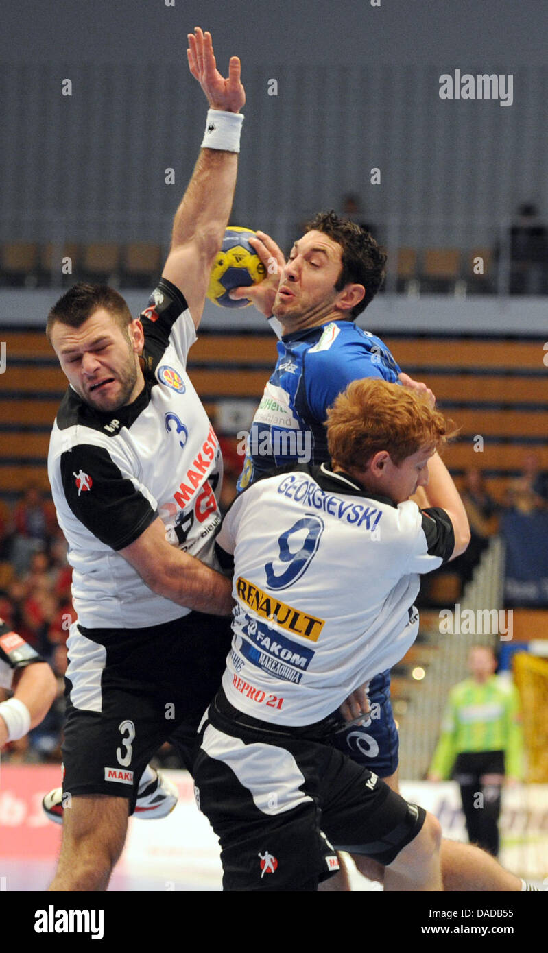 Hamburg player Blazenko Lackovic (C) is blocked by Metalurg players ...