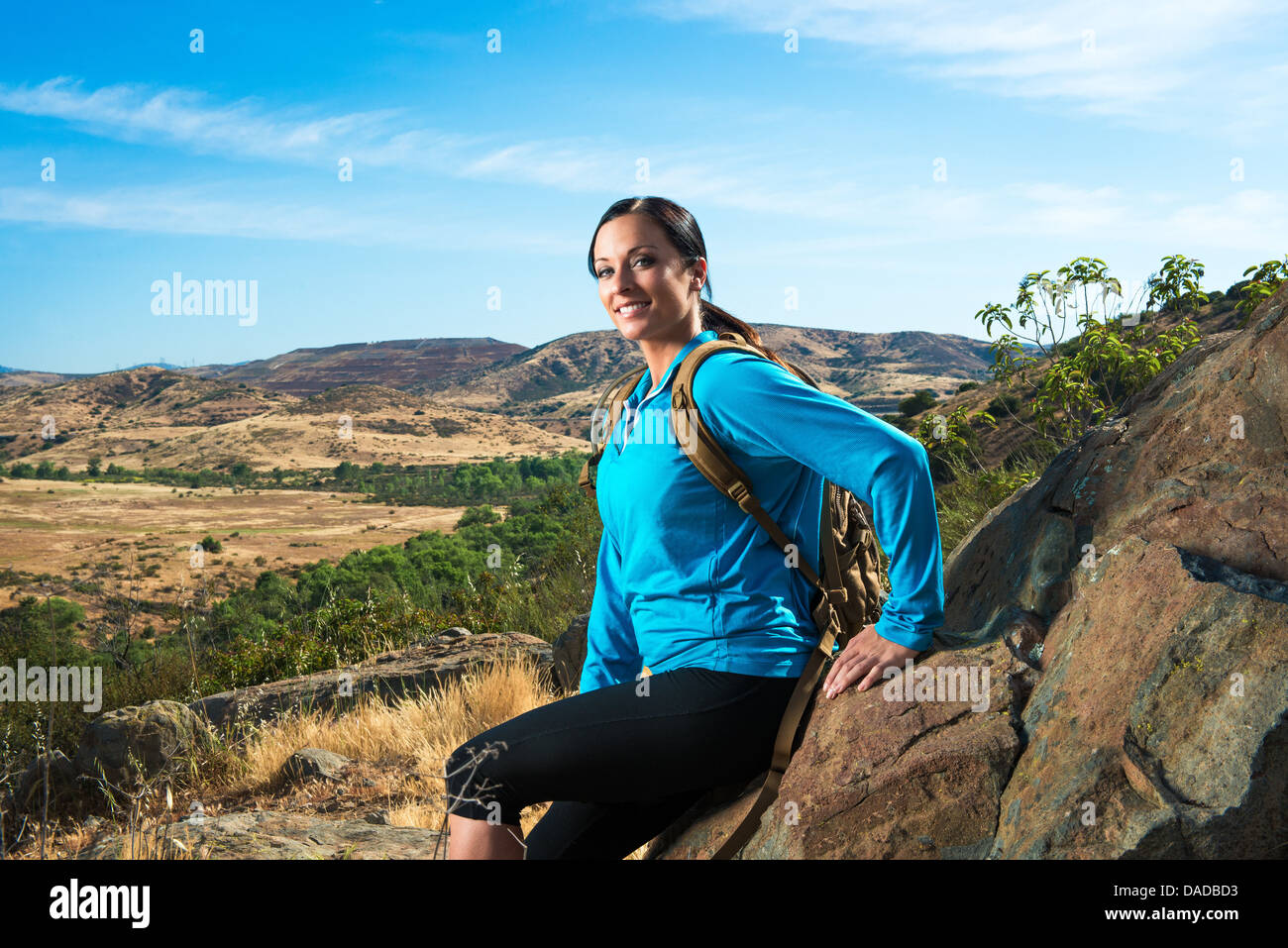 Female hiker sitting on rock Stock Photo - Alamy