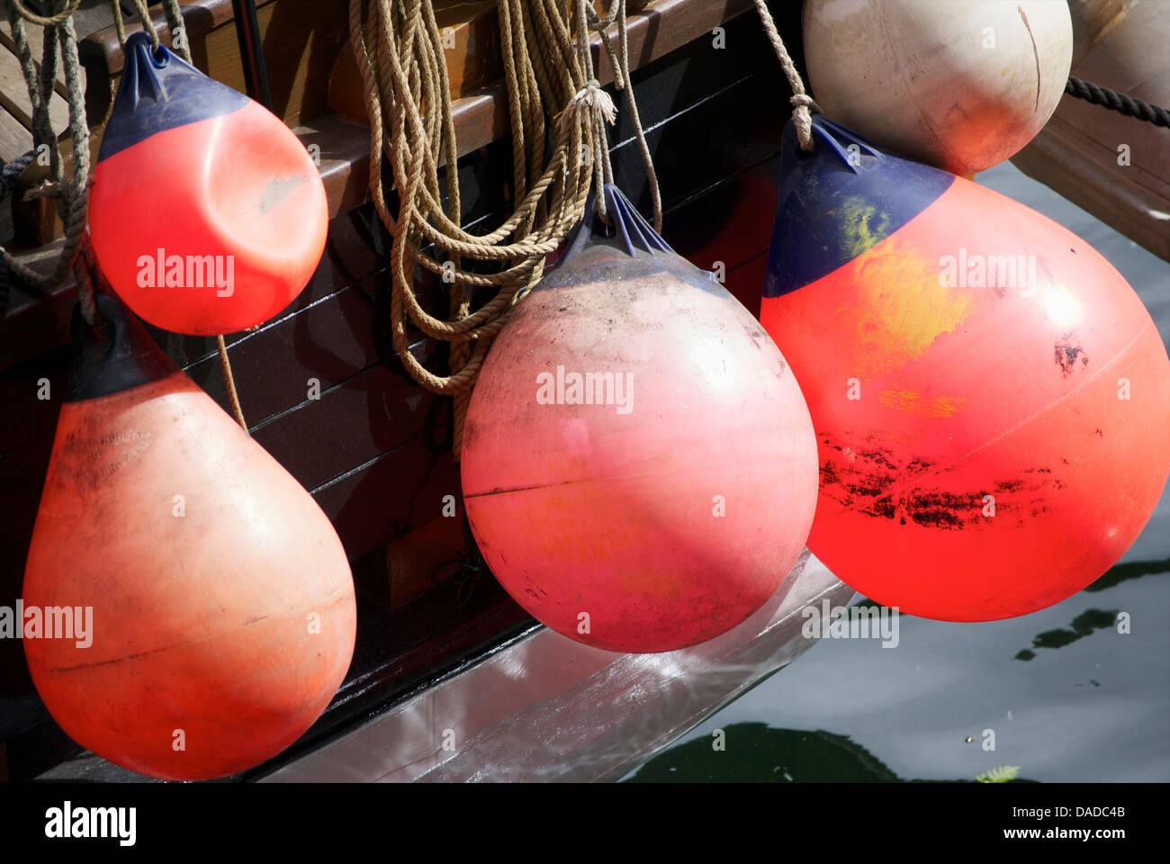 Round buoys tied to the side of a boat with rigging/rope Stock Photo ...