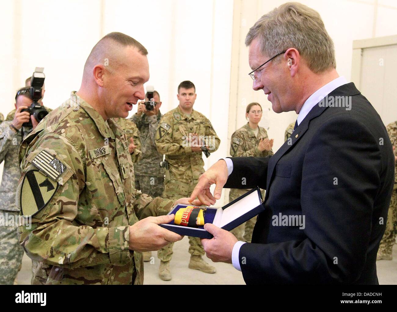 German President Christian Wulff presents a German campaign streamer to ...