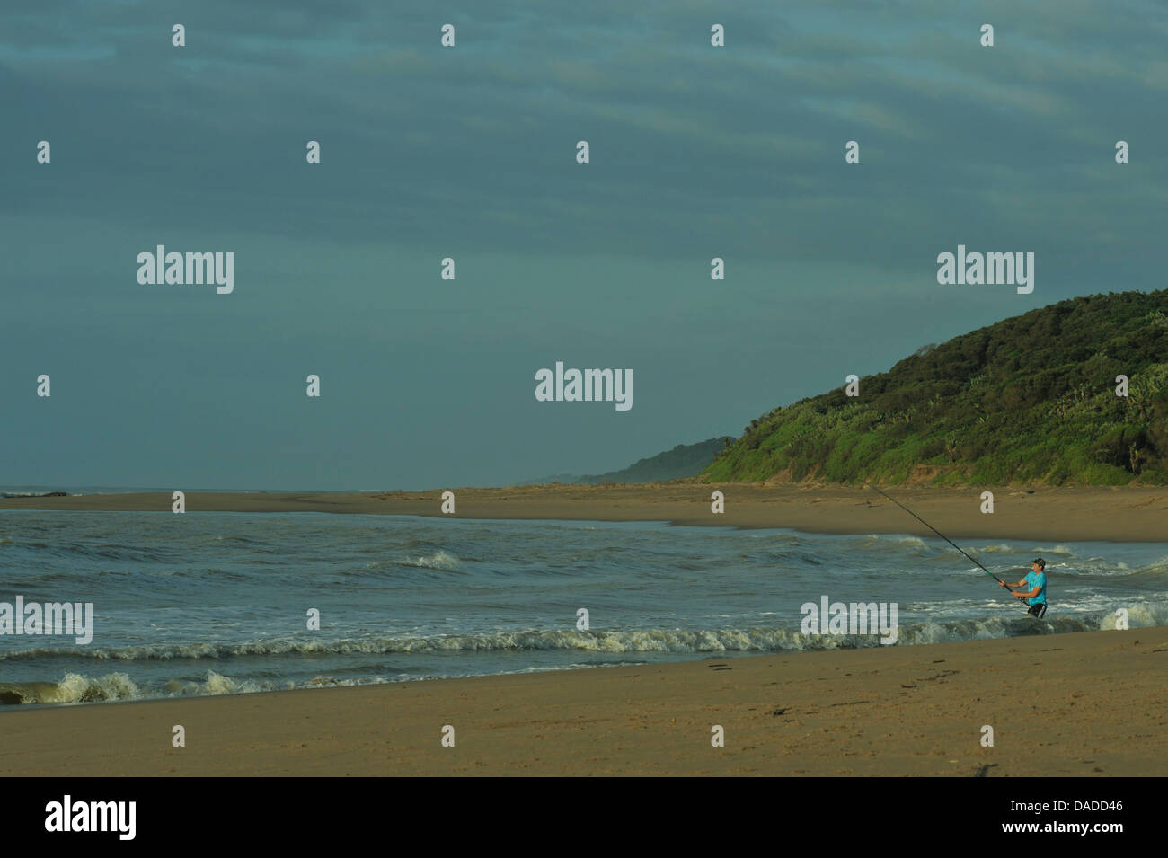 Scene of man standing in surf doing sea angling at Tugela River Mouth ...