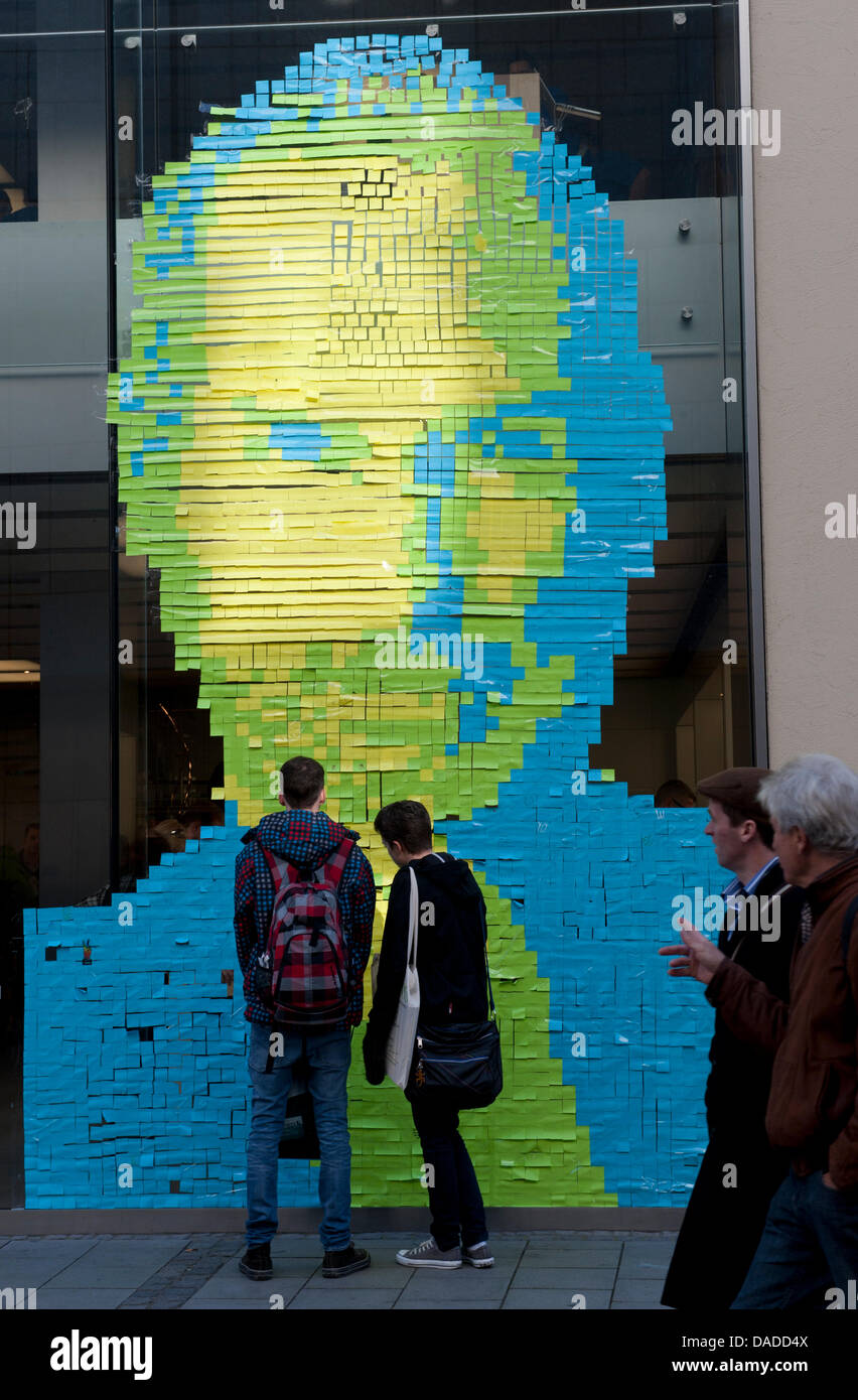 Passers-by stand in front of a giant portrait of died Apple founder ...