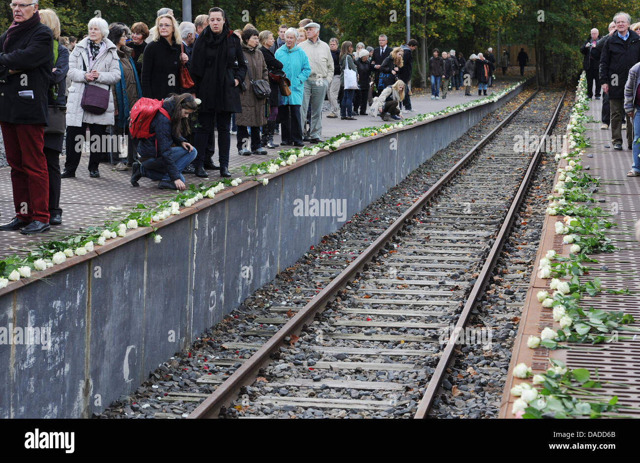 People assemble and lay white roses on platform 17 in Grunewald Station ...