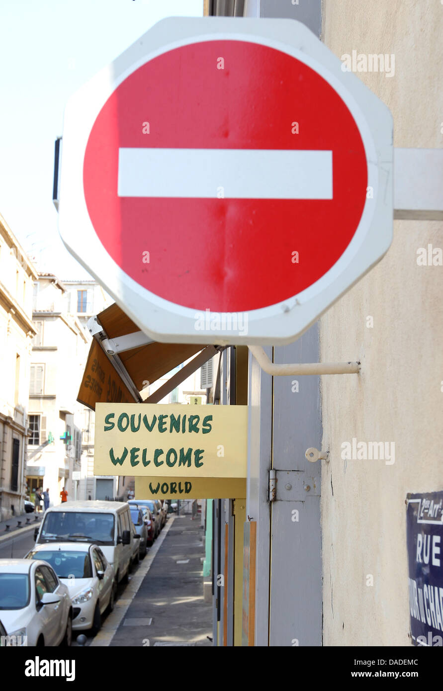 A 'Souvenirs Welcome' sign stands behind a 'Passage Prohibited' sign in ...