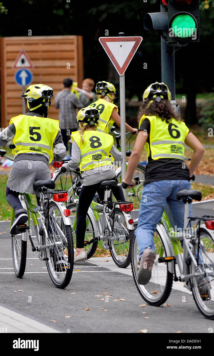 School children ride on bicycles during a practice lesson at the ...