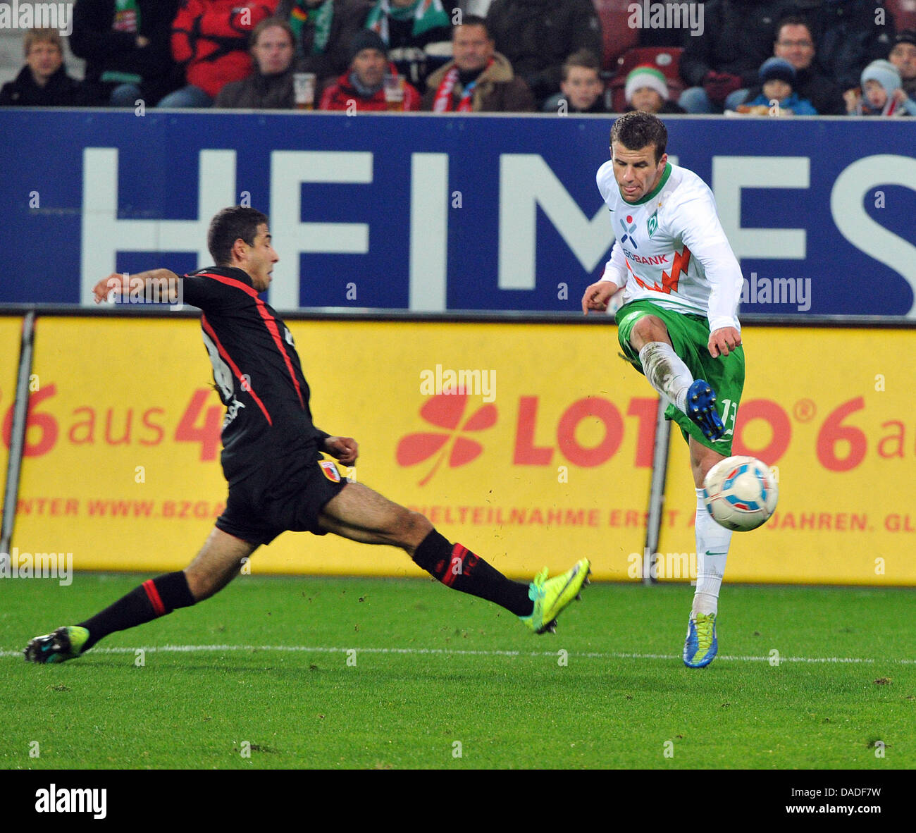 Bremen player Lukas Schmitz (R) plays the ball while Augsburg player ...