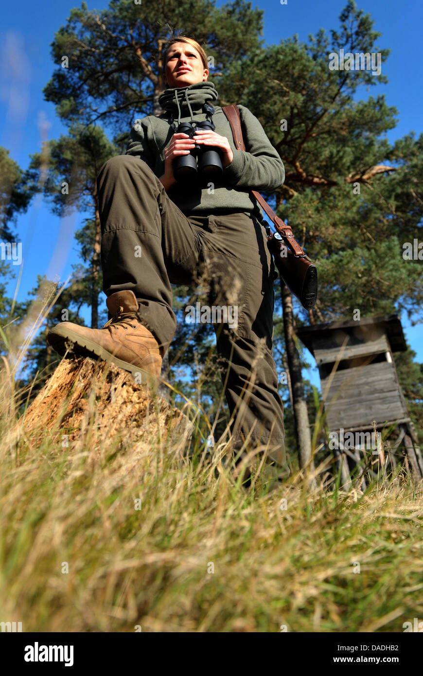 The young hunter Johanna Koehler poses on a shooting seat in a forest ...