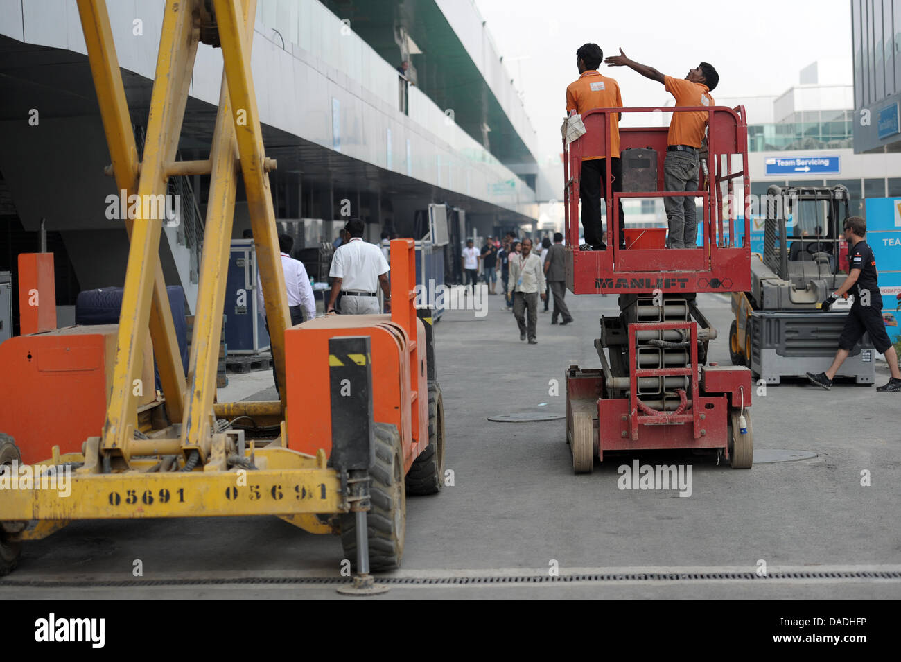 Workers are photographed during the final preparations in the paddock ...