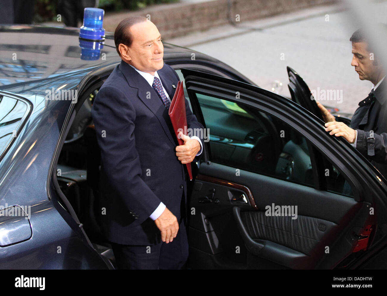 Italian Prime Minister Silvio Berlusconi gets out of his car upon his ...
