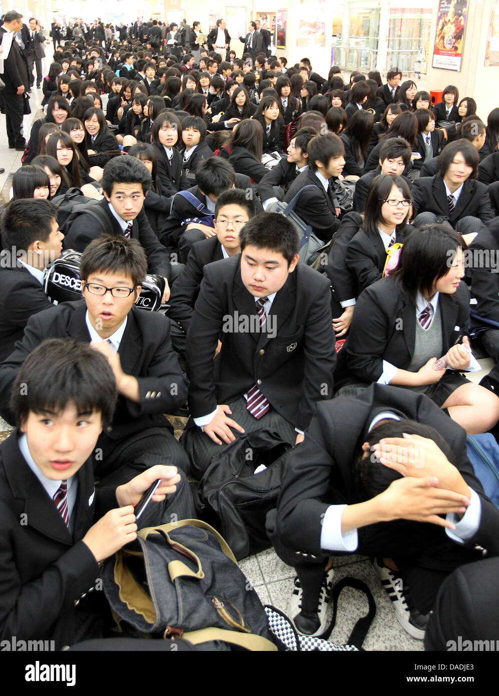 Pupils wait for their train at the central railway station in Kyoto ...