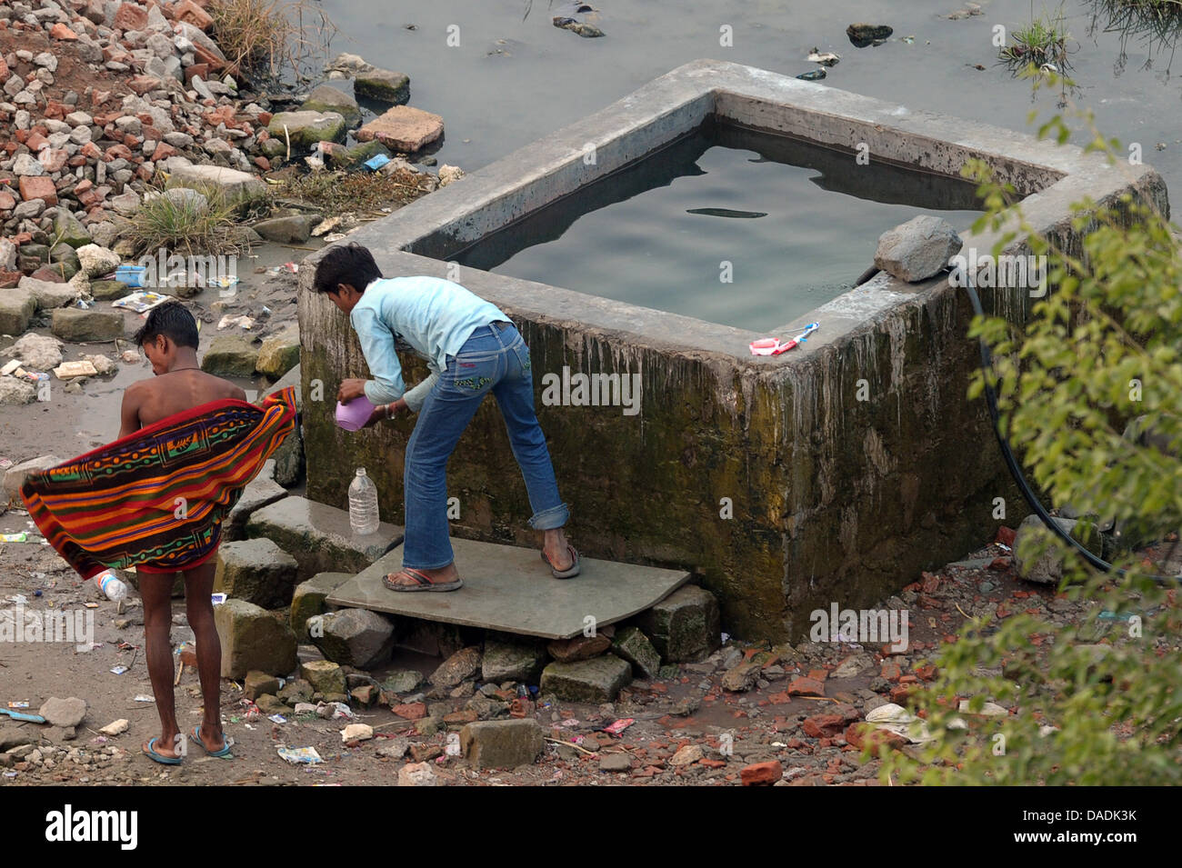 Indian people have a wash in the morning at a water well, Noida, India ...