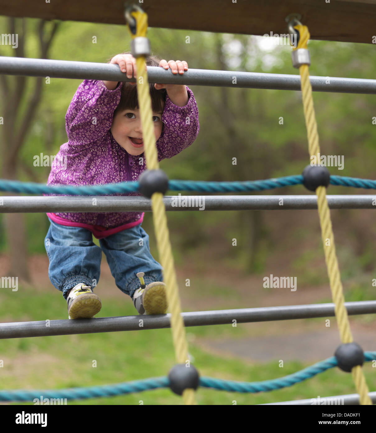 Young girl on climbing frame in playground, portrait Stock Photo - Alamy