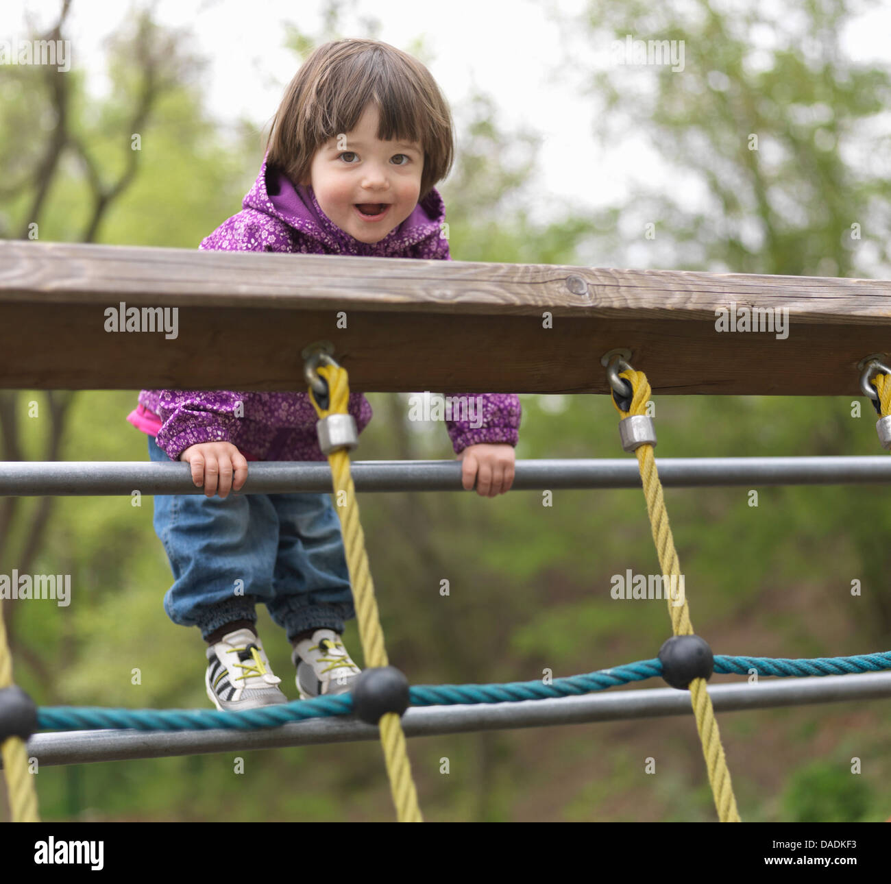 Young girl on climbing frame in playground, portrait Stock Photo - Alamy