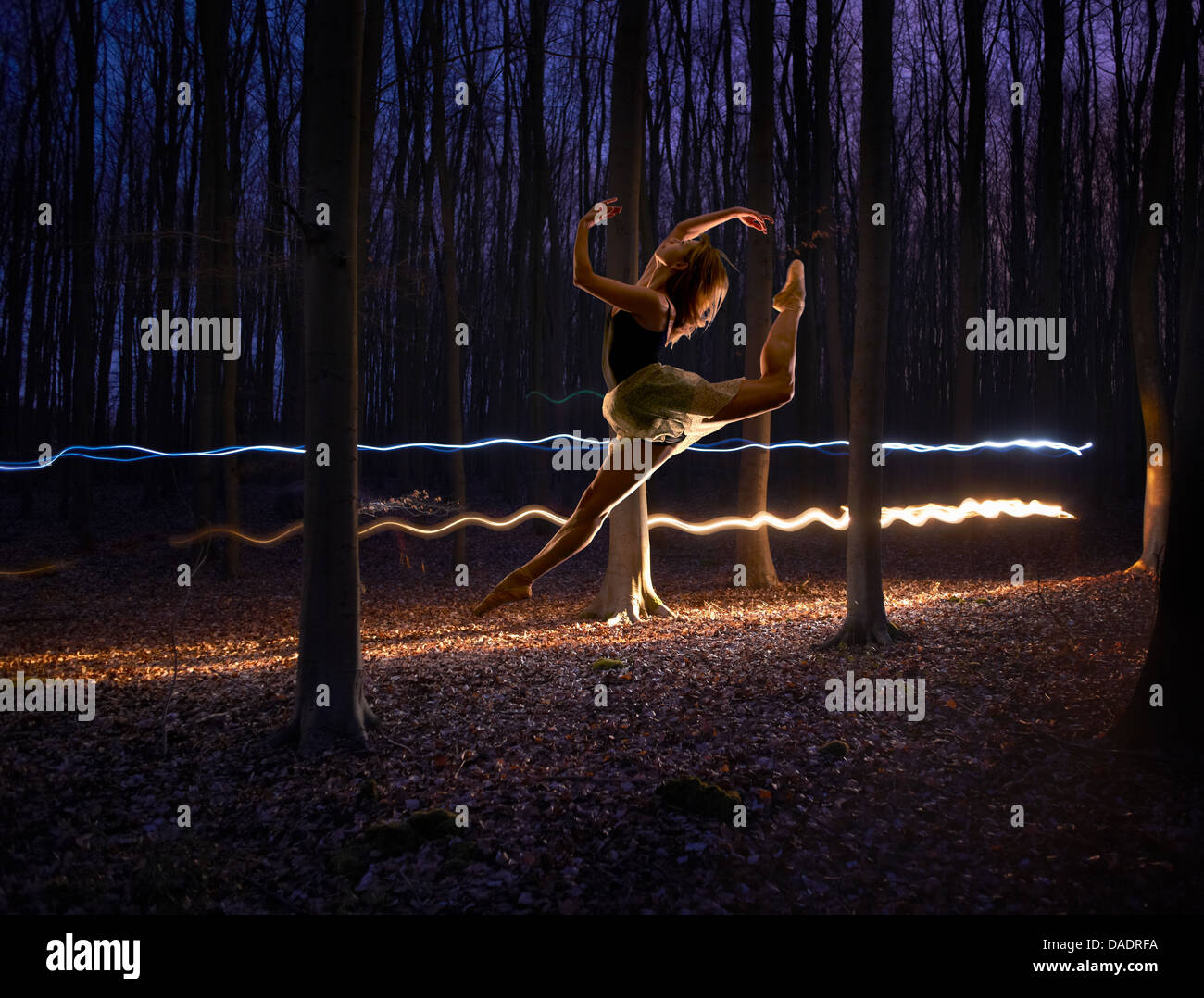 Female dancer jumping mid air in darkened forest Stock Photo - Alamy