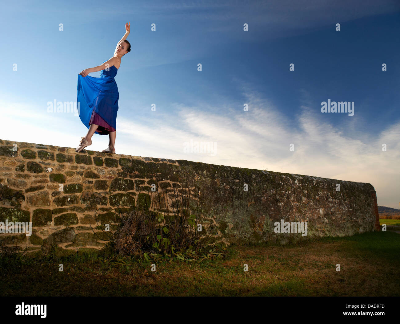 Female dancer poised on stone wall Stock Photo - Alamy