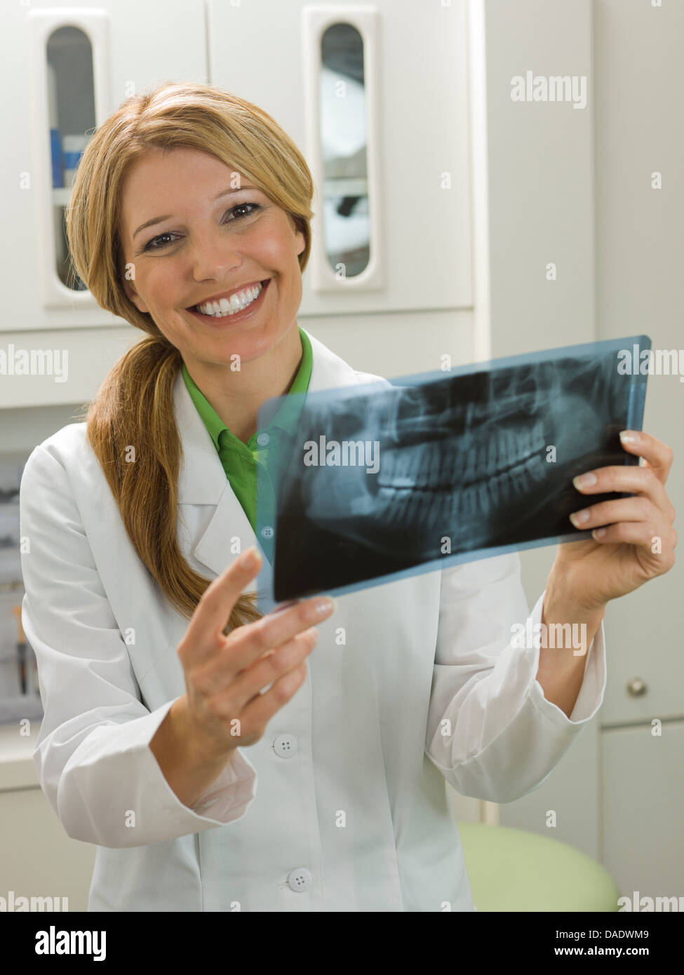Dentist looking at x-ray, smiling Stock Photo - Alamy