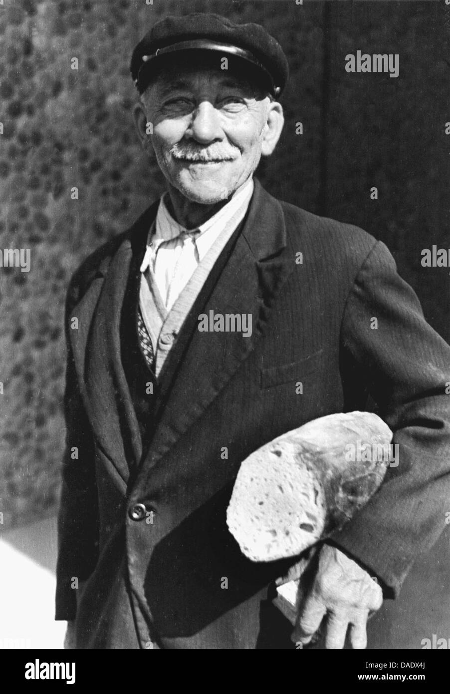 Paris 1937, man holding loaf of bread under his arm. Image by ...