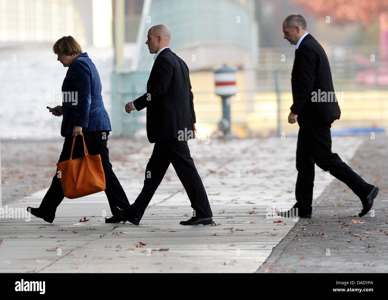 German Chancellor Angela Merkel (L) and her security personnel walk ...