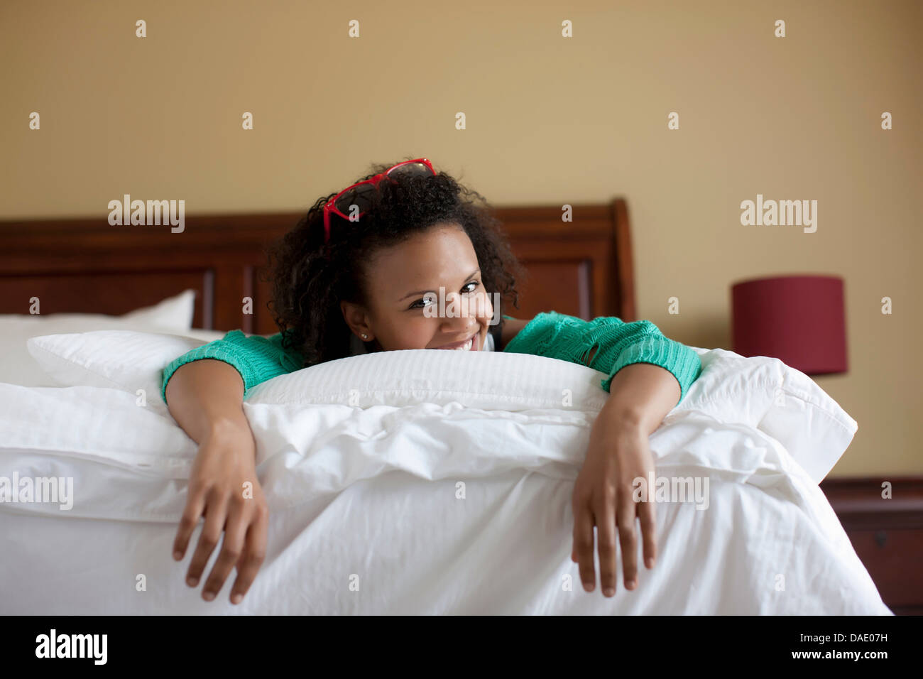 Young woman lying on bed Stock Photo - Alamy