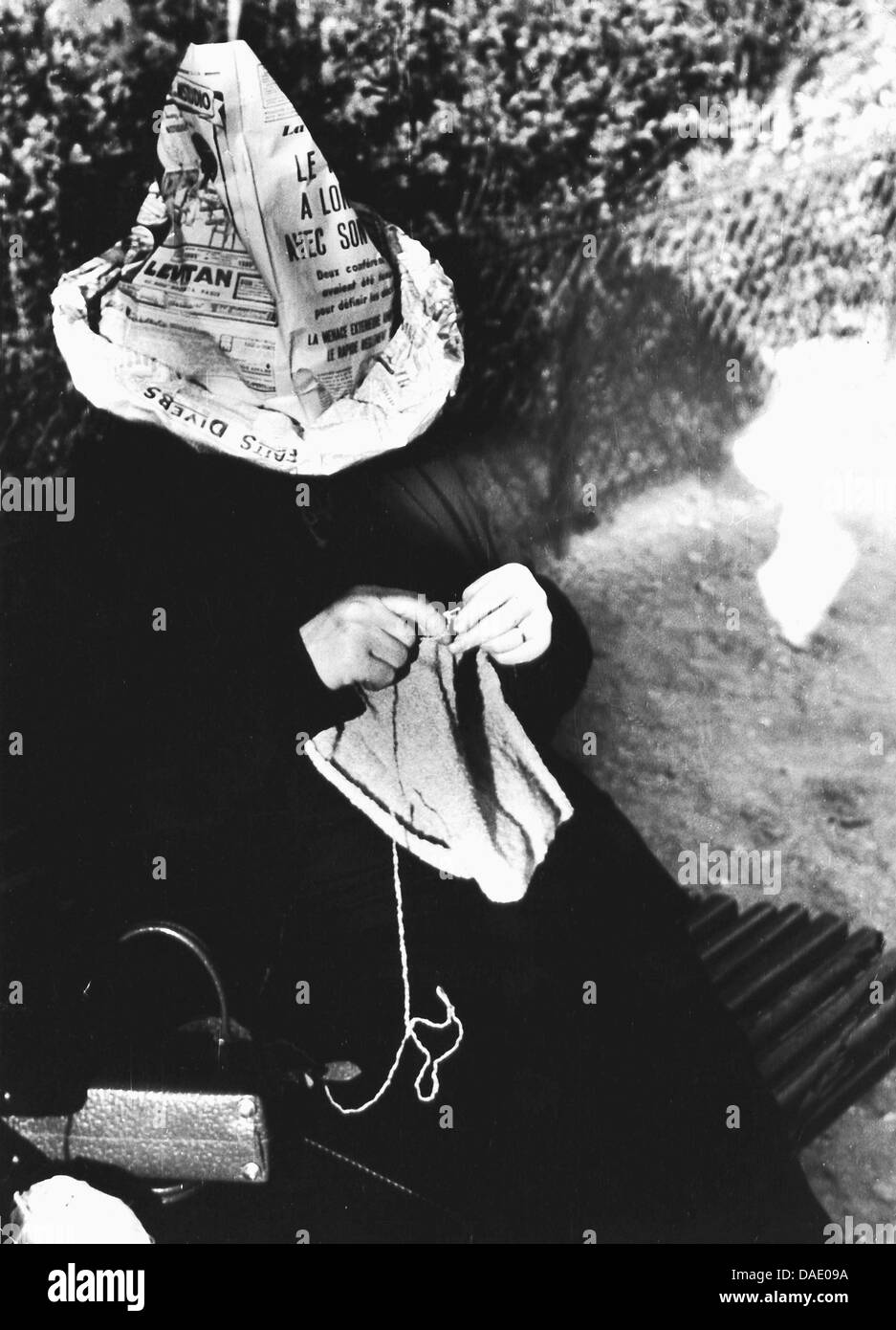 Paris 1933, woman with a paper bag on her head while knitting. Image by ...