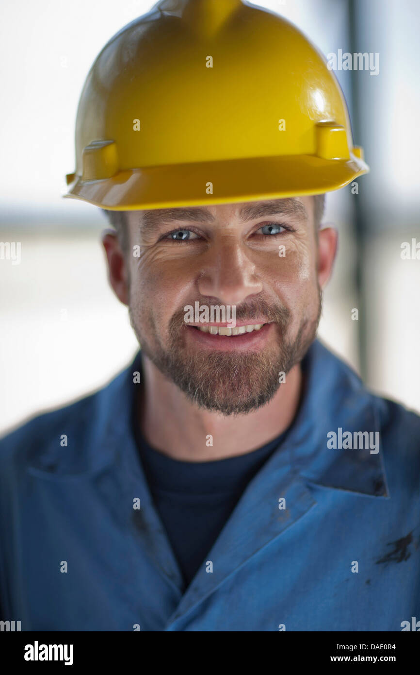 Mid adult construction worker wearing hard hat, smiling Stock Photo - Alamy