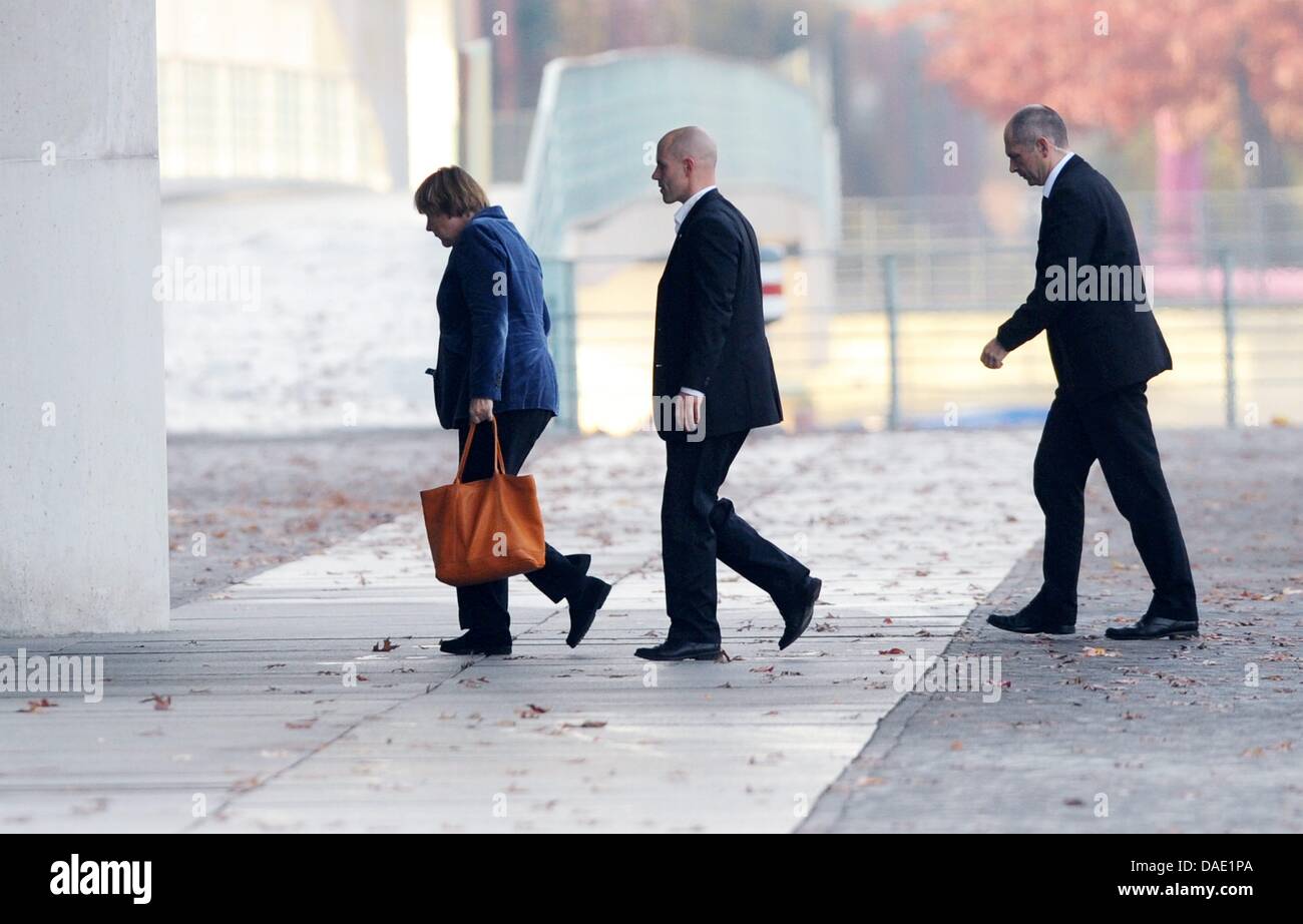 German Chancellor Angela Merkel (L) and her security personnel walk ...