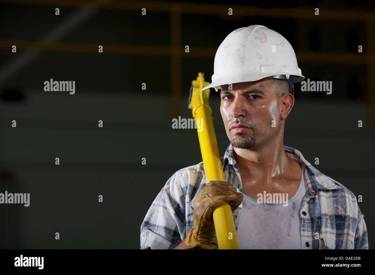 Mid adult construction worker wearing hard hat and holding tool ...