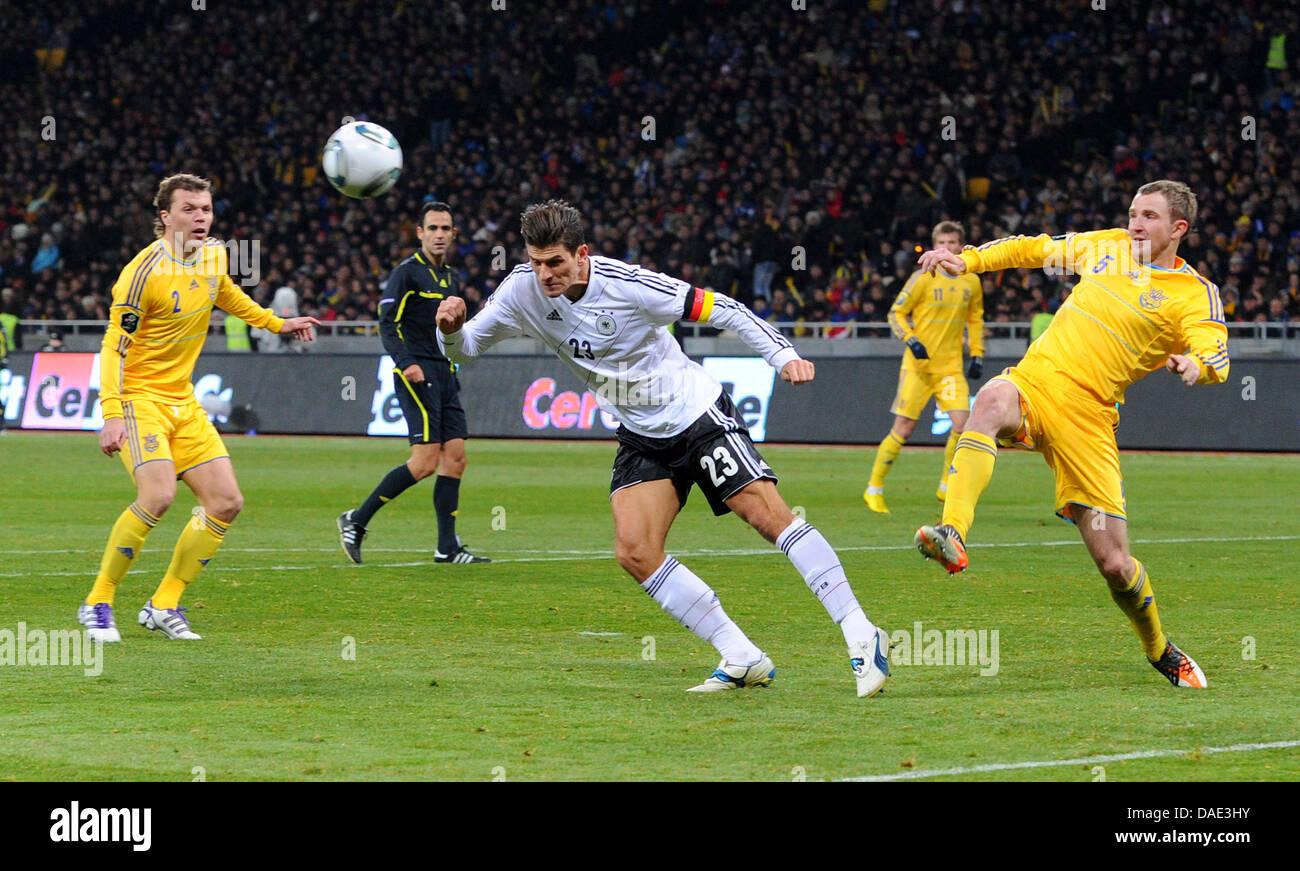 Ukraine's Oleksandr Kucher (r) and Germany's Mario Gomez (C) fight for ...