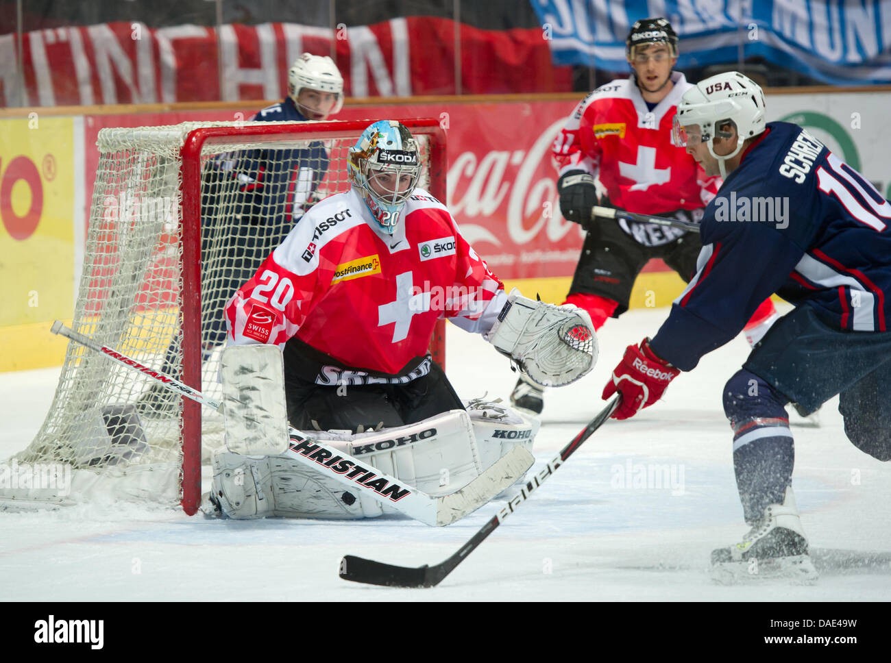 Swiss hockey goalkeeper Reto Berra (L) parades the puck of attacking US ...