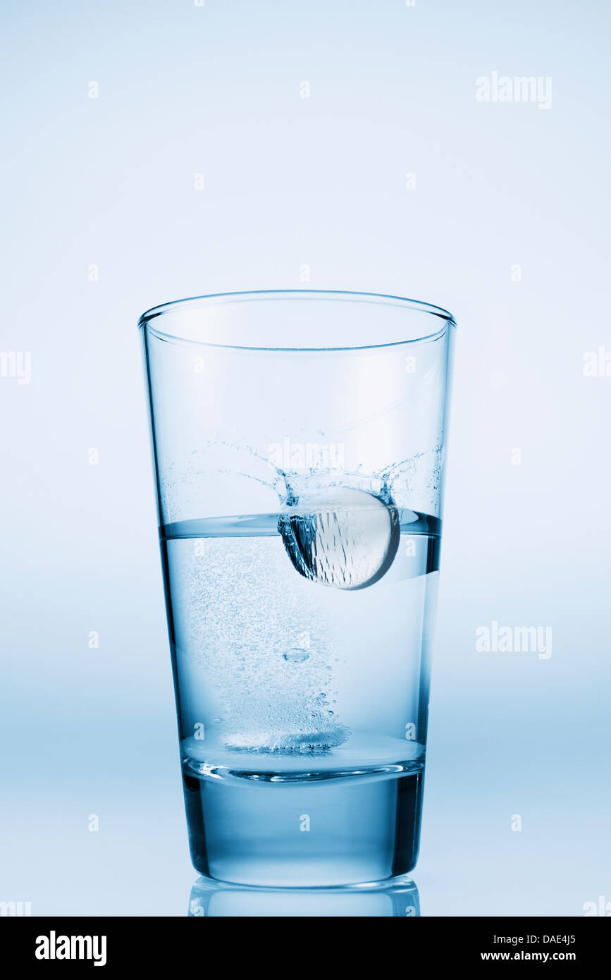 Tablet falling in glass of water Stock Photo - Alamy