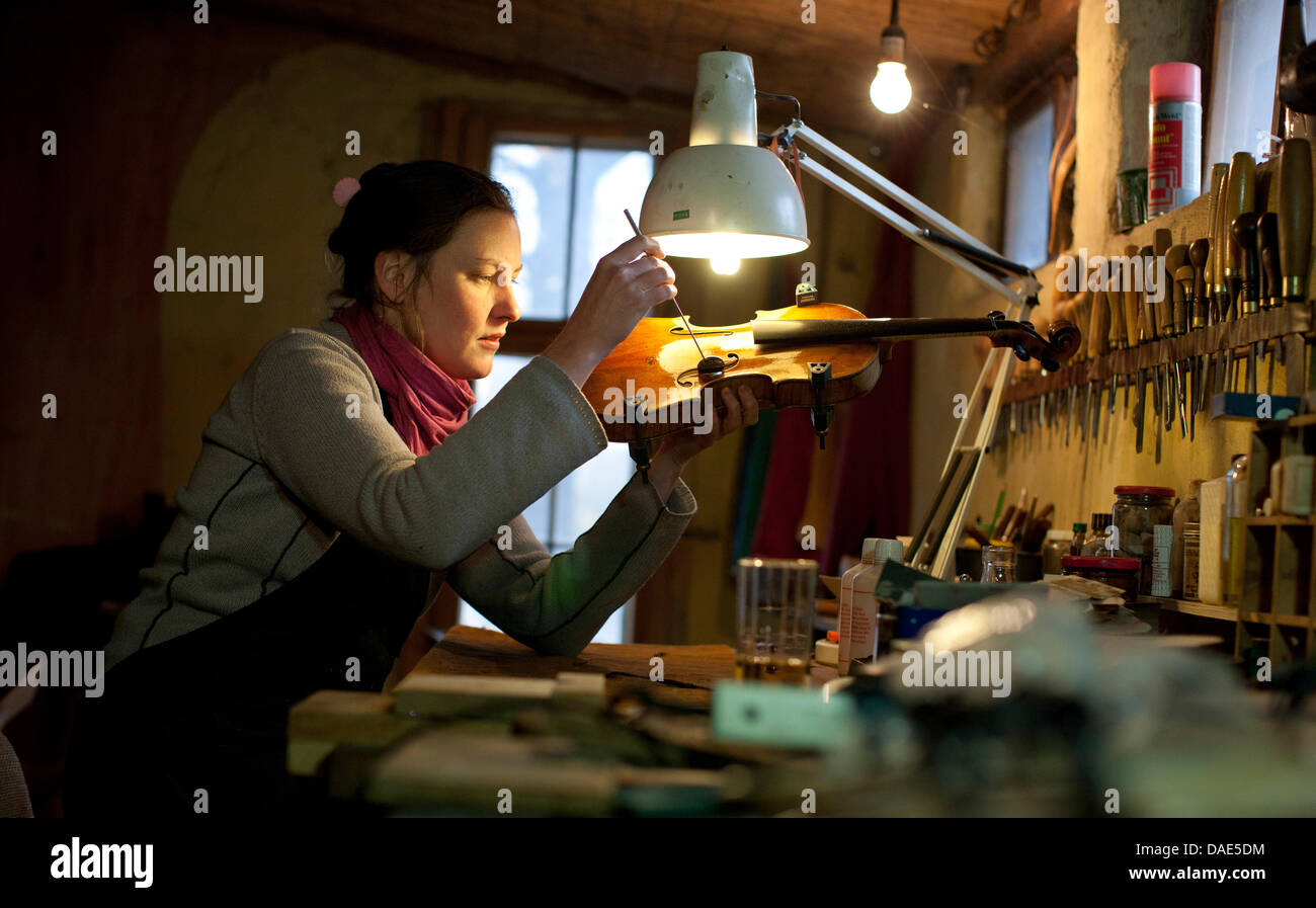 Instrument maker Kim Baker works on a violin inside her shop in Dresden ...