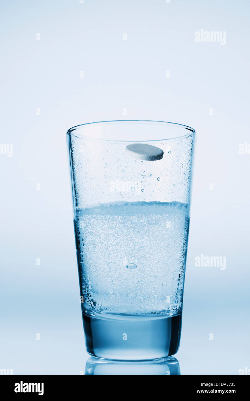 Tablet falling in glass of water Stock Photo - Alamy