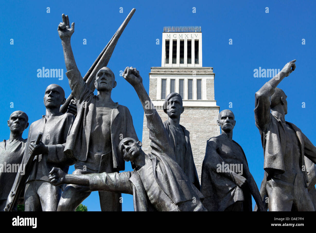 A set of bronze sculptures stand in front of the bell tower of the ...