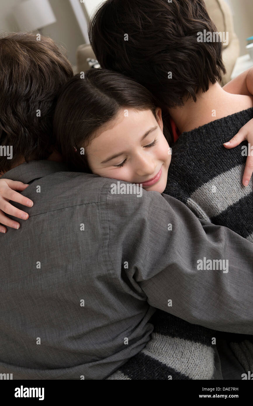 Parents hugging daughter Stock Photo - Alamy