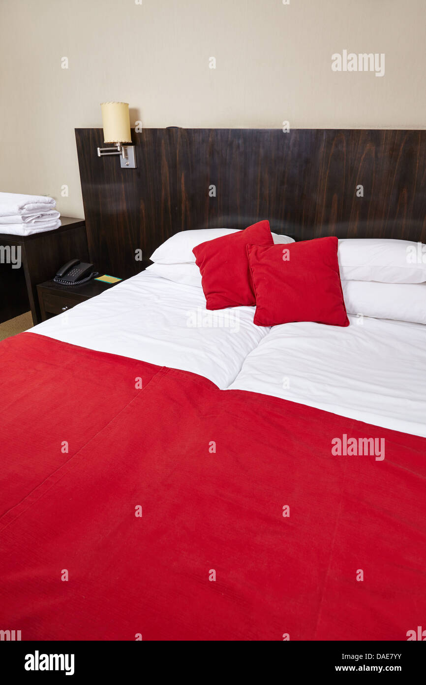 Clean red bed in a luxury hotel room Stock Photo - Alamy