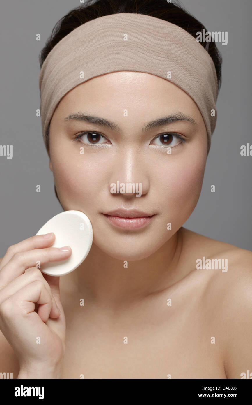 Young woman using make up sponge Stock Photo - Alamy