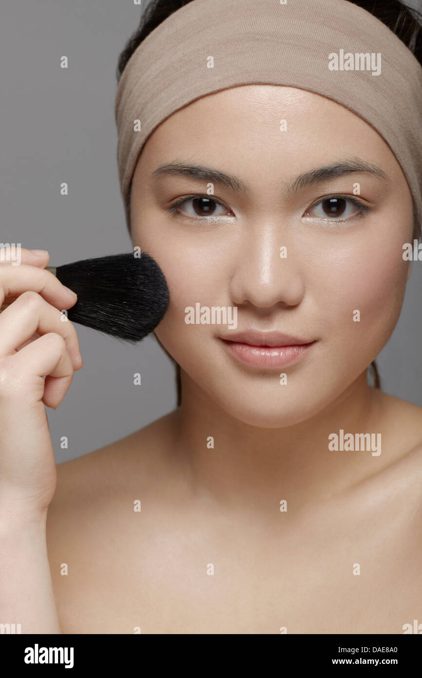 Young woman applying blusher Stock Photo - Alamy