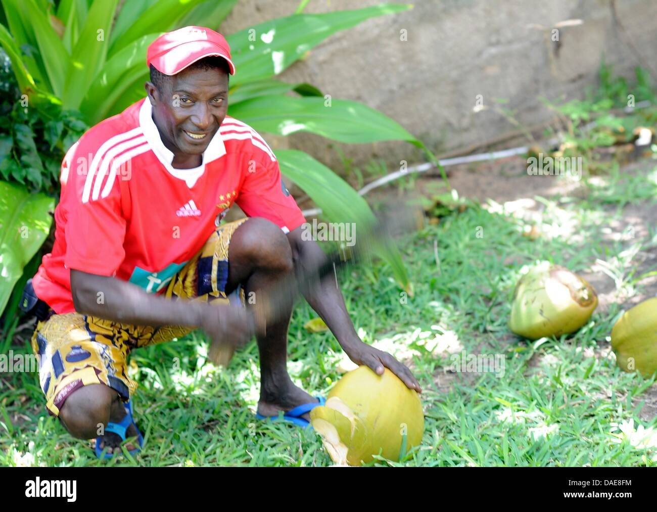 A man opens a coconut in Inhambane, Mozambique, 03 March 2013. Photo ...
