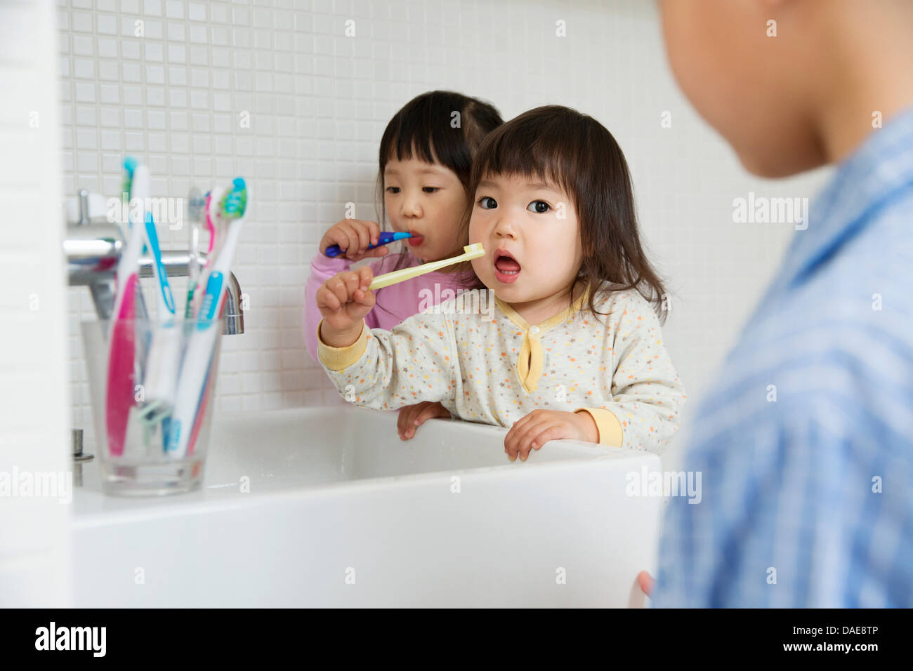 Two girls brushing teeth at bathroom sink Stock Photo - Alamy
