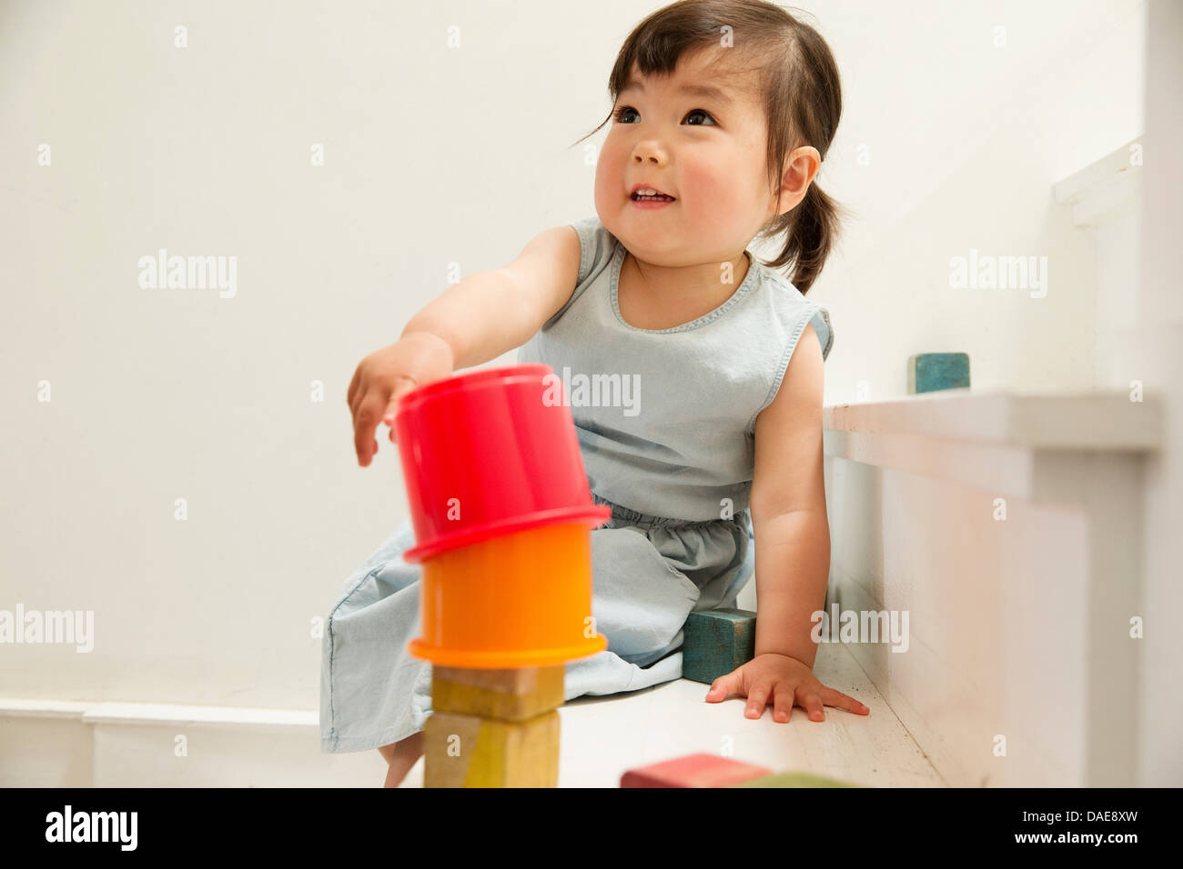 Female toddler on stairs building tower Stock Photo - Alamy
