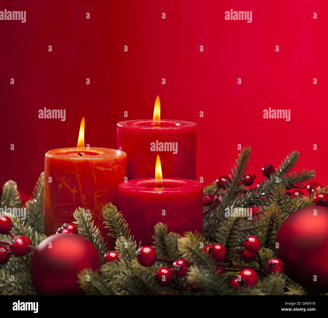 Red advent flower arangement with burning candles Stock Photo - Alamy