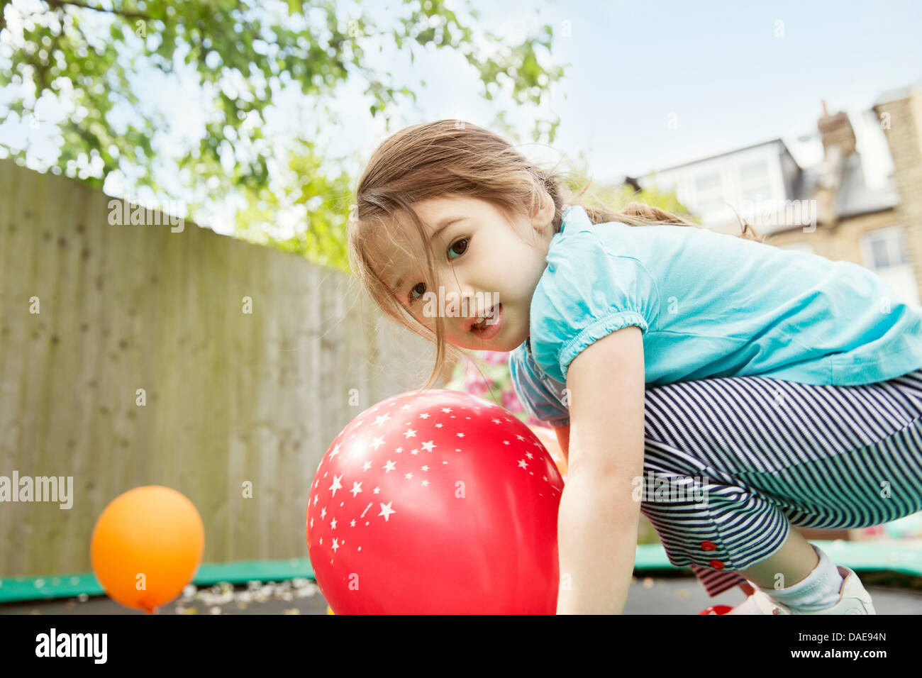 Young girl playing in garden with balloons Stock Photo - Alamy