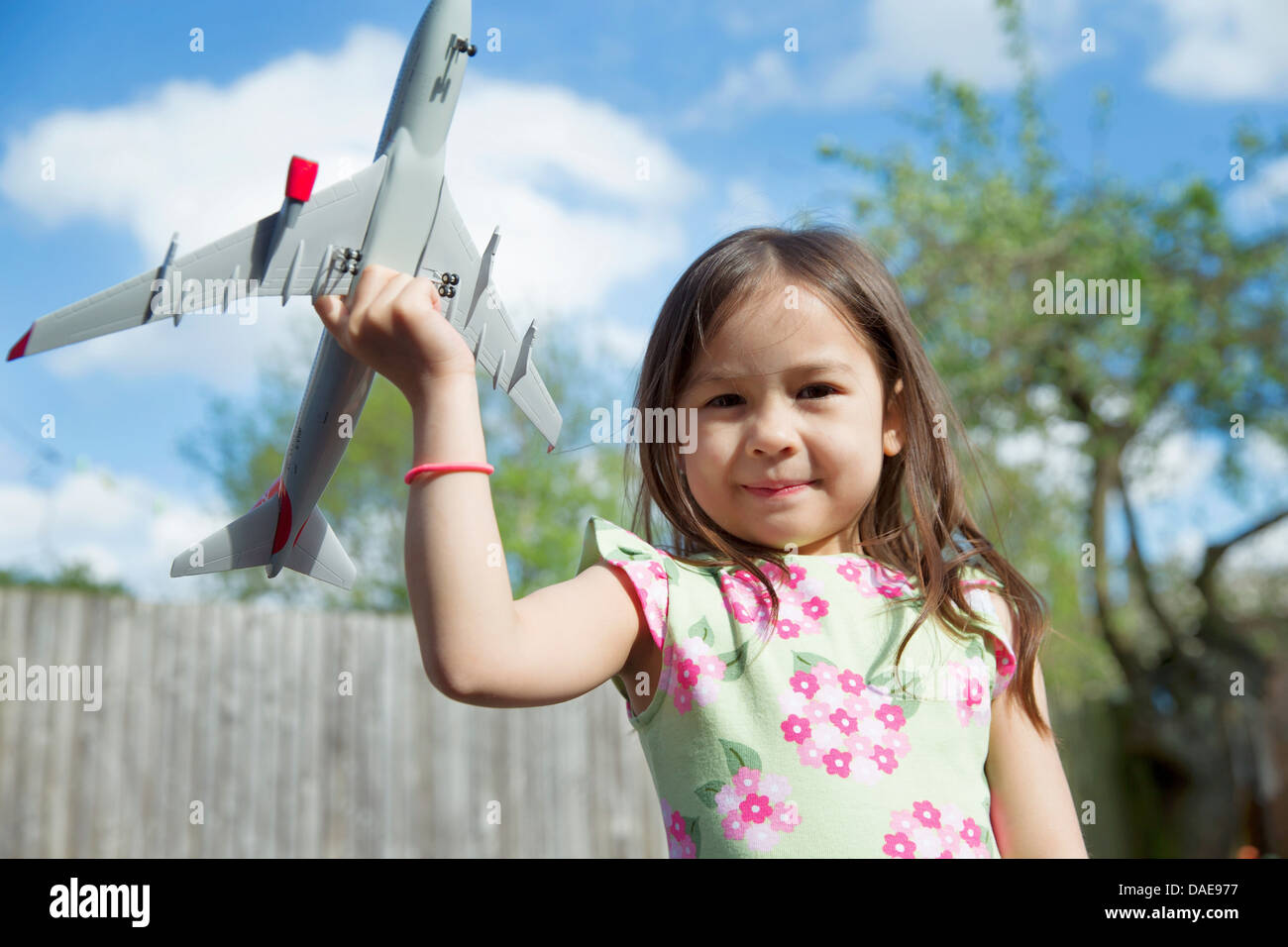 Portrait of young girl in garden holding toy airplane Stock Photo - Alamy