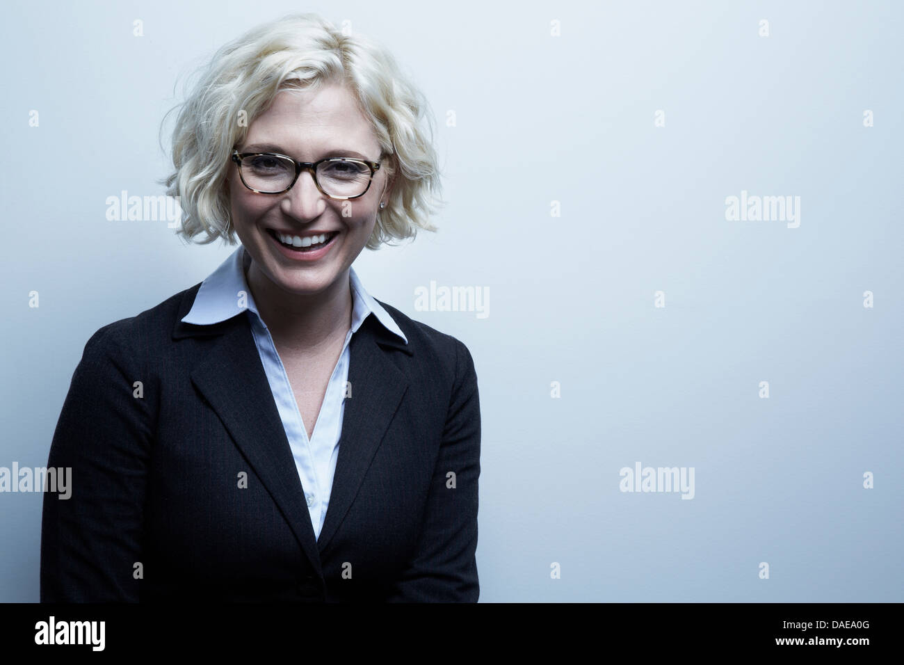 Studio portrait of blond businesswoman smiling Stock Photo - Alamy