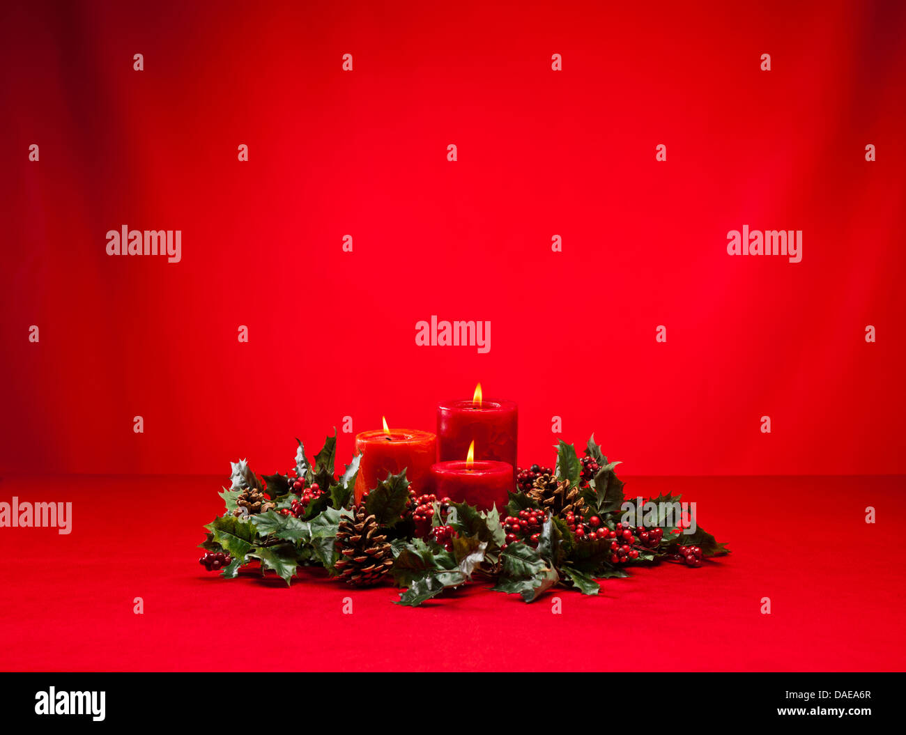 Red advent flower arangement with burning candles Stock Photo - Alamy