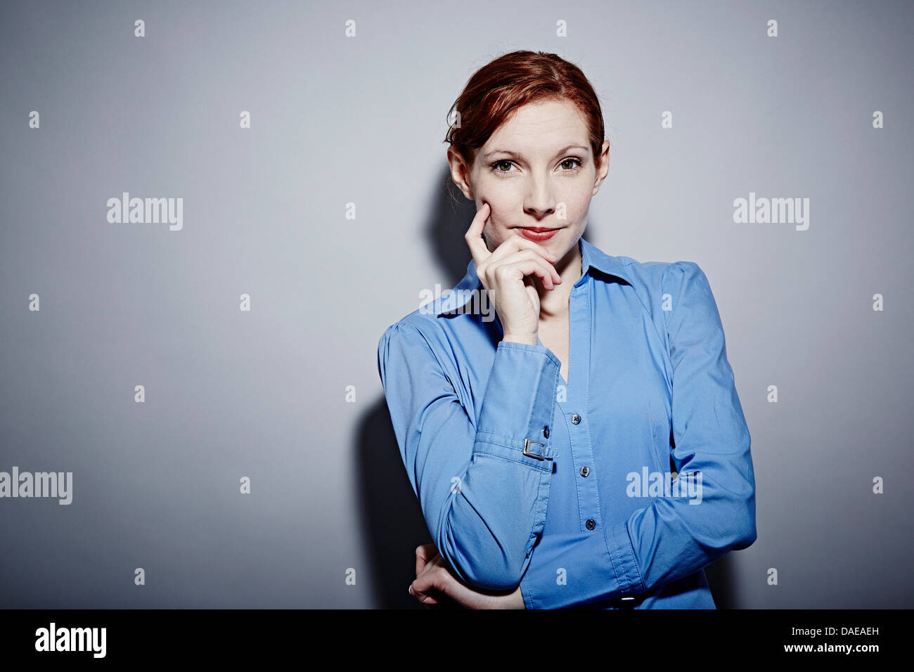 Young woman with hand on chin hi-res stock photography and images - Alamy